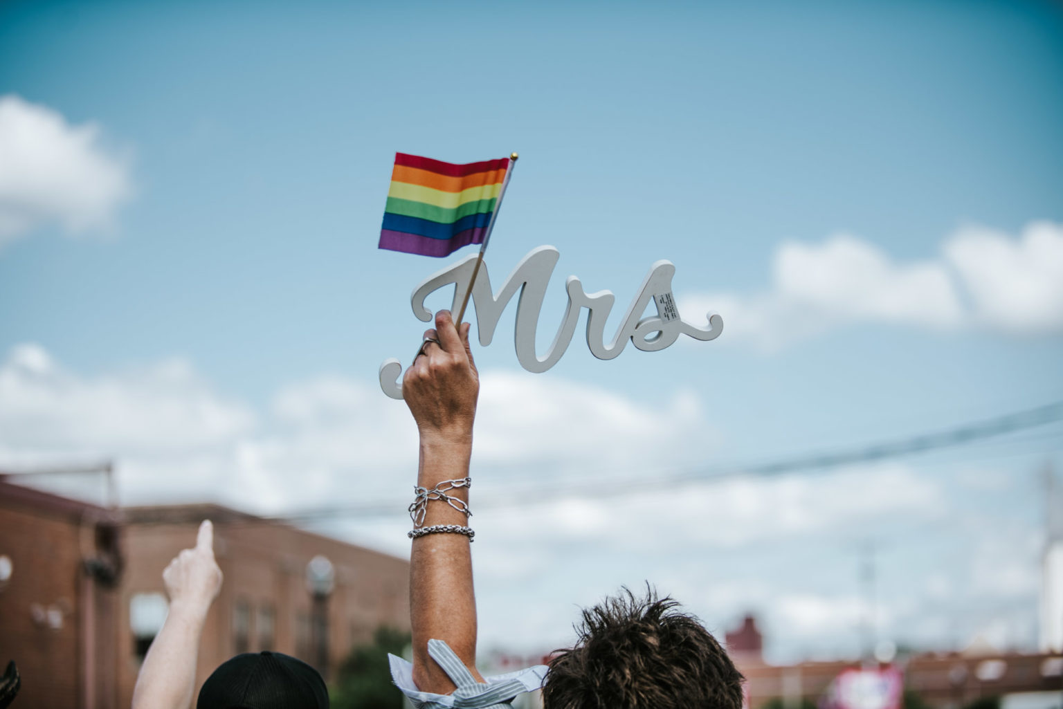 Relaxed and cozy Tennessee wedding with floral arch and pride flags